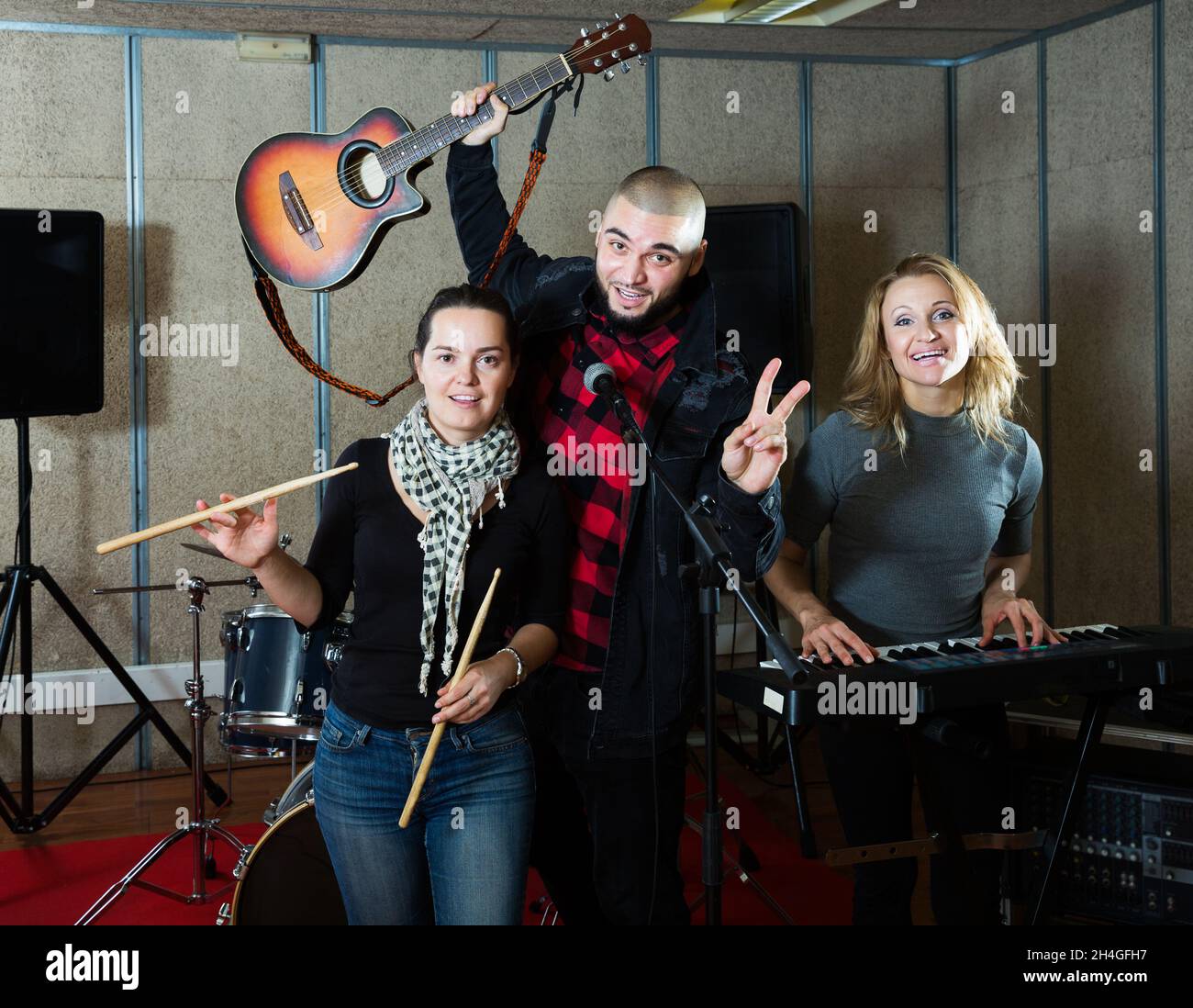 expressive group of rock musicians posing with instruments Stock Photo ...