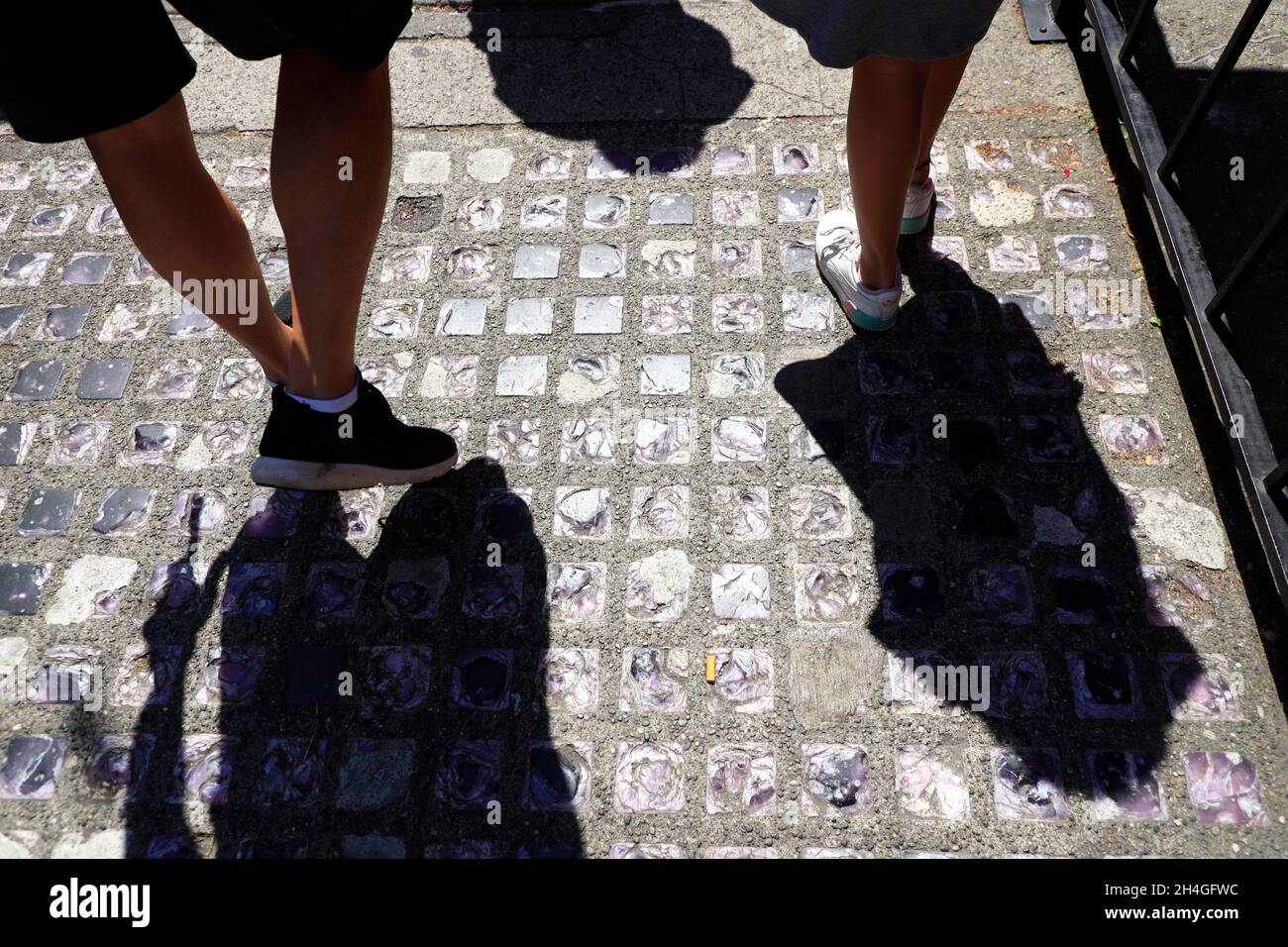 People walking over the glass skylights on sidewalk of Underground ...