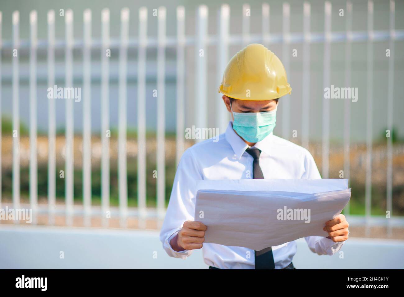 Engineer hold paper work or blueprint and survey on site construction ...