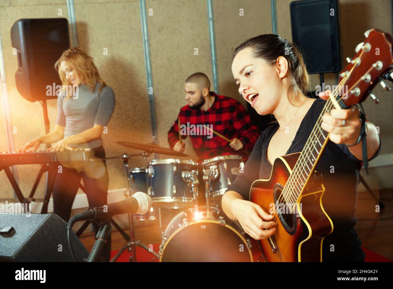 Attractive female soloist playing guitar and singing with her mu Stock ...