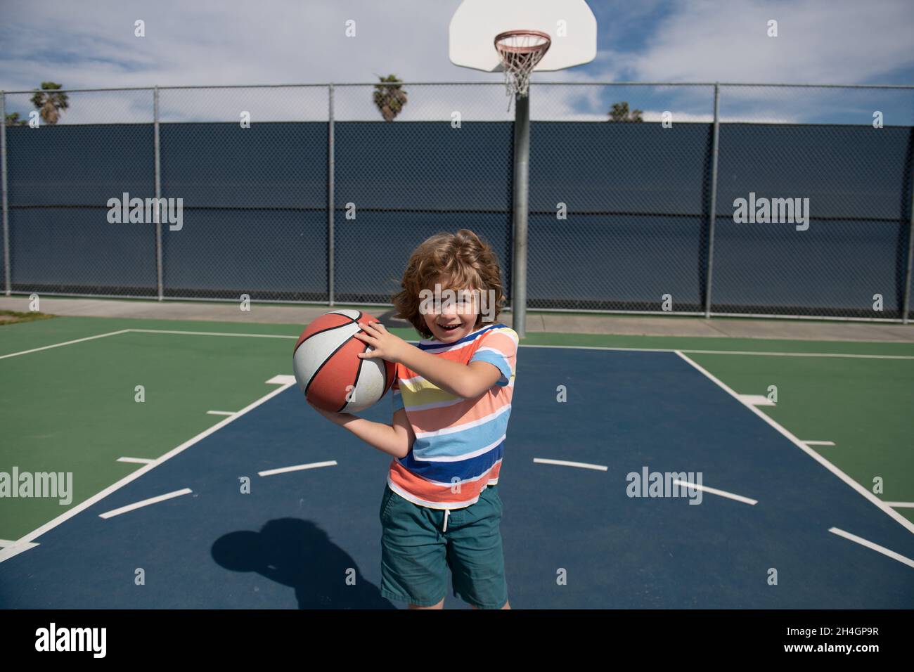 Cute child playing basketball. Kid playing basketball with basket ball ...