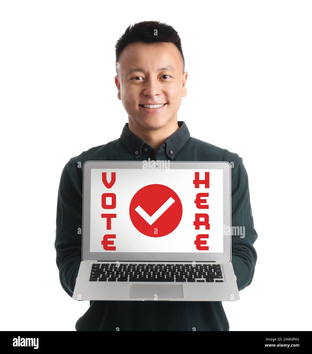 Young Asian man holding laptop with text VOTE HERE on screen against ...
