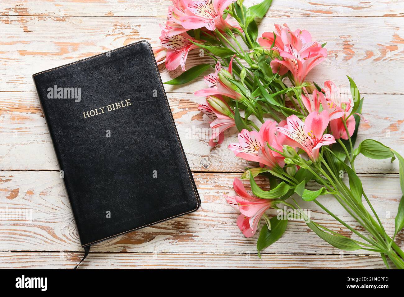 Holy Bible and lily flowers on light wooden background Stock Photo - Alamy