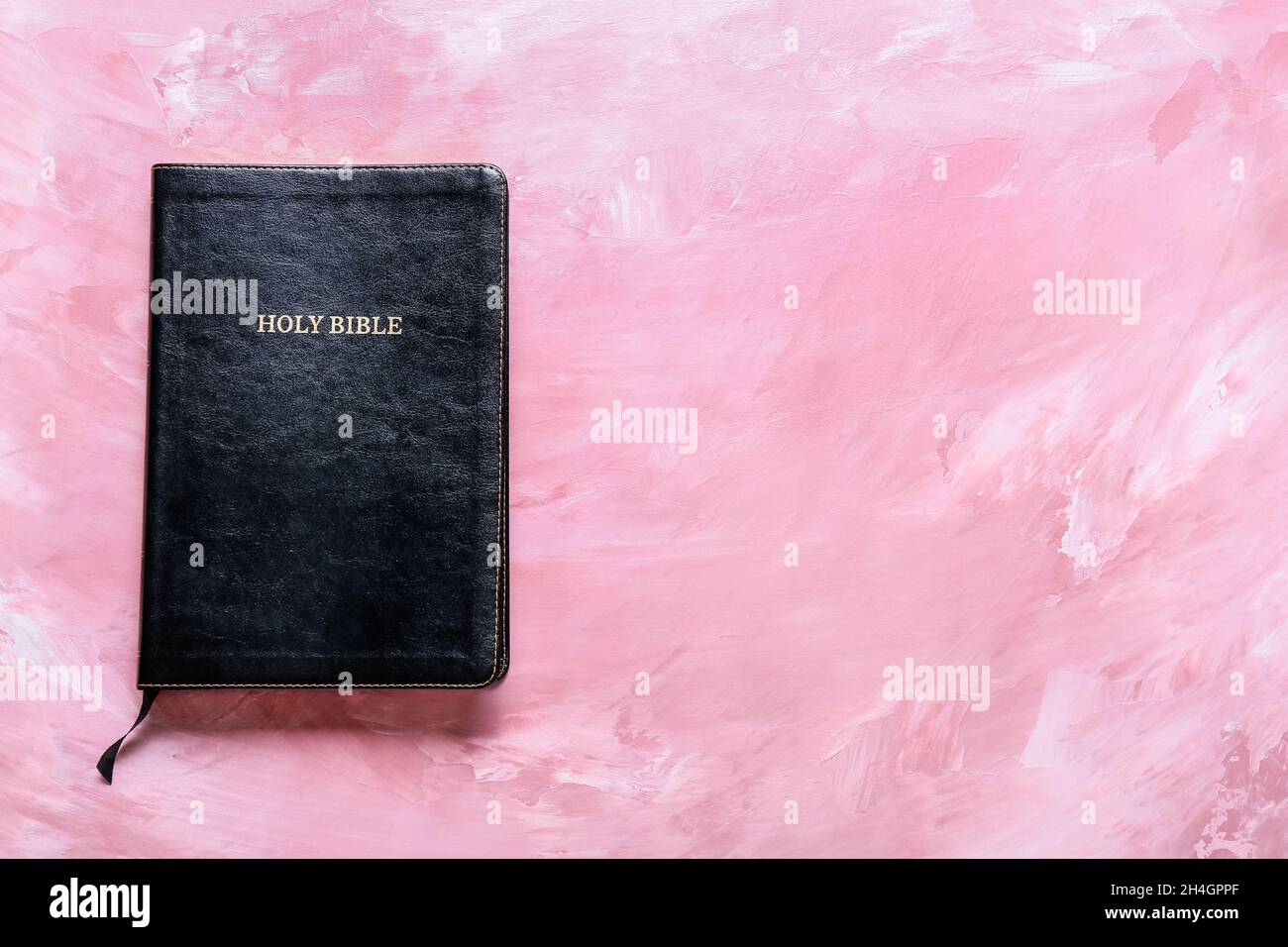 Holy Bible on pink background Stock Photo - Alamy
