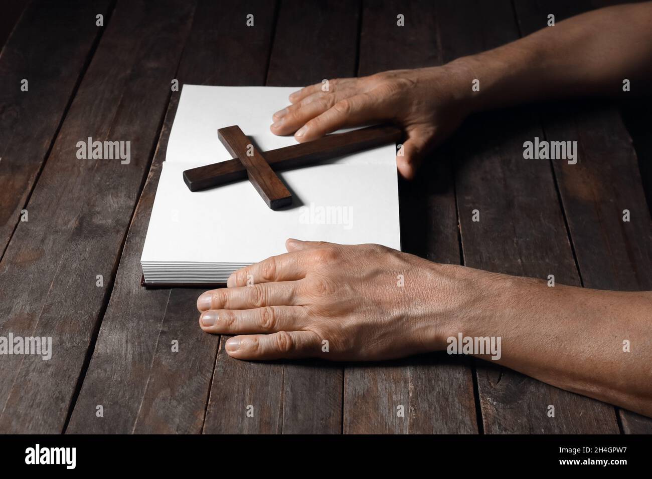 Man with cross and Holy Bible on dark wooden background Stock Photo - Alamy