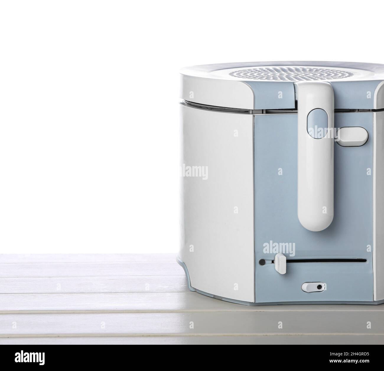 Modern deep fryer on table against white background Stock Photo - Alamy