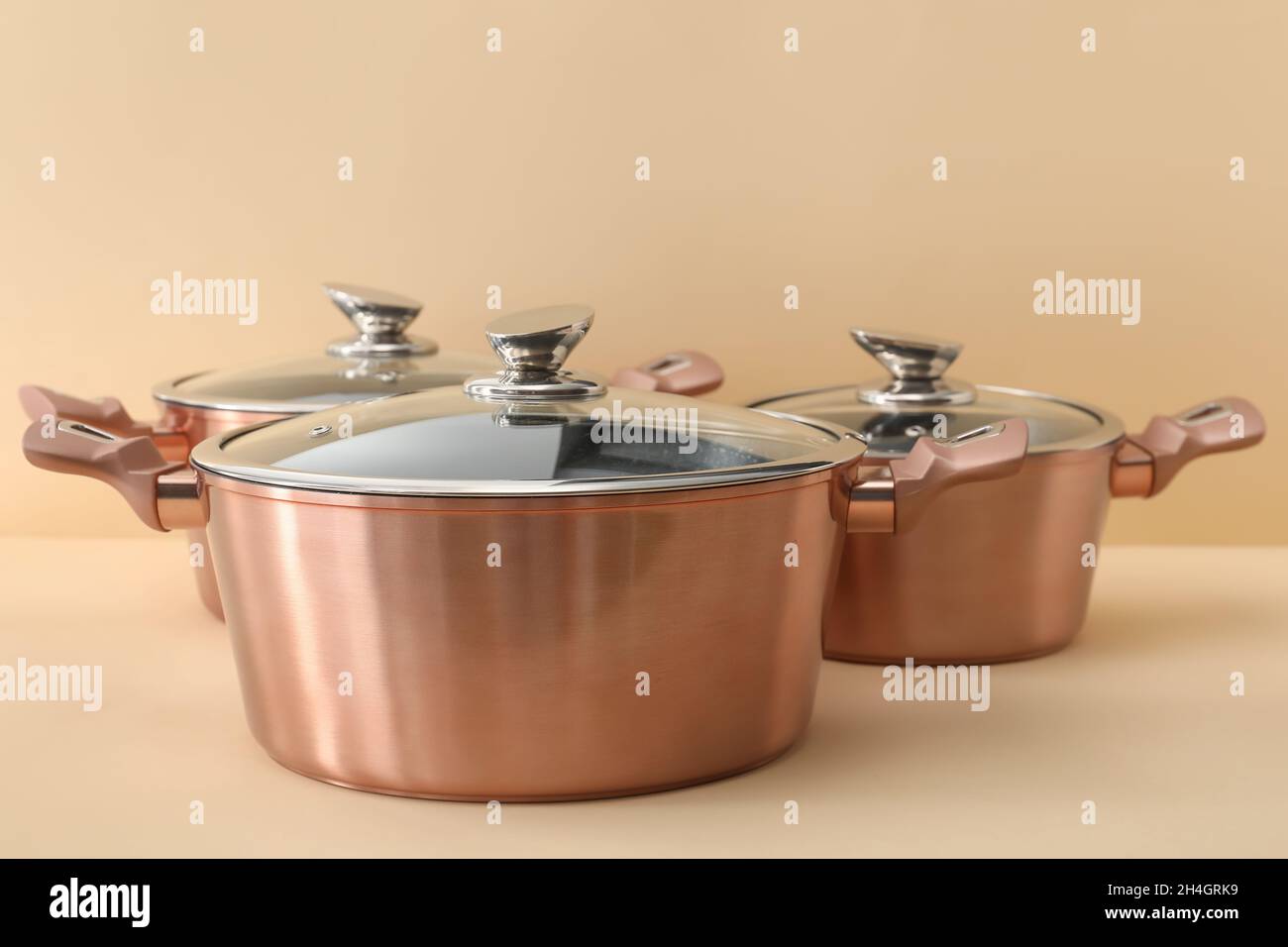 New steel cooking pots with glass ladle on light background Stock Photo ...