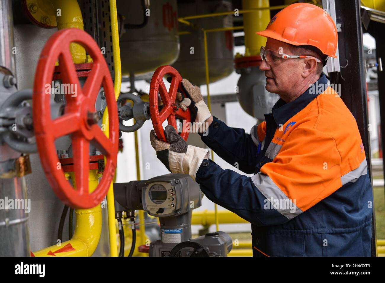 Gas station worker controls gas valve at a natural gas station during ...