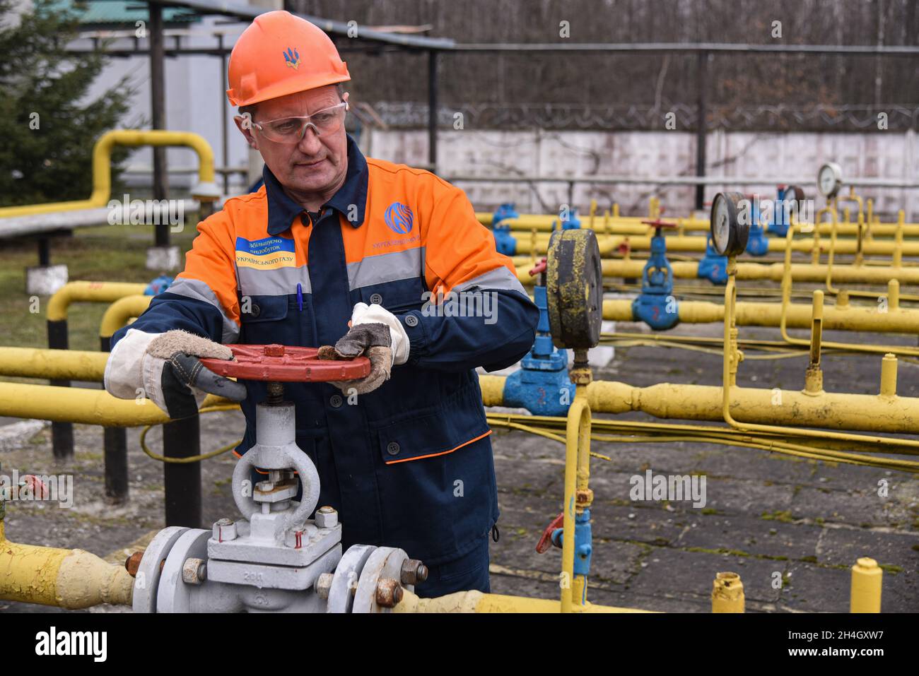 Gas station worker controls gas valve at a natural gas station during ...