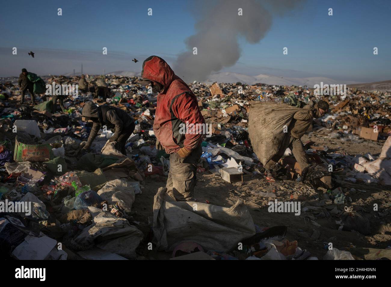 Men search through waste in one of the main city's dump site ...