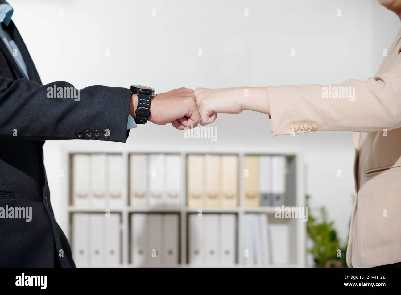 Close-up image of business colleagues making fist bump gesture as a ...