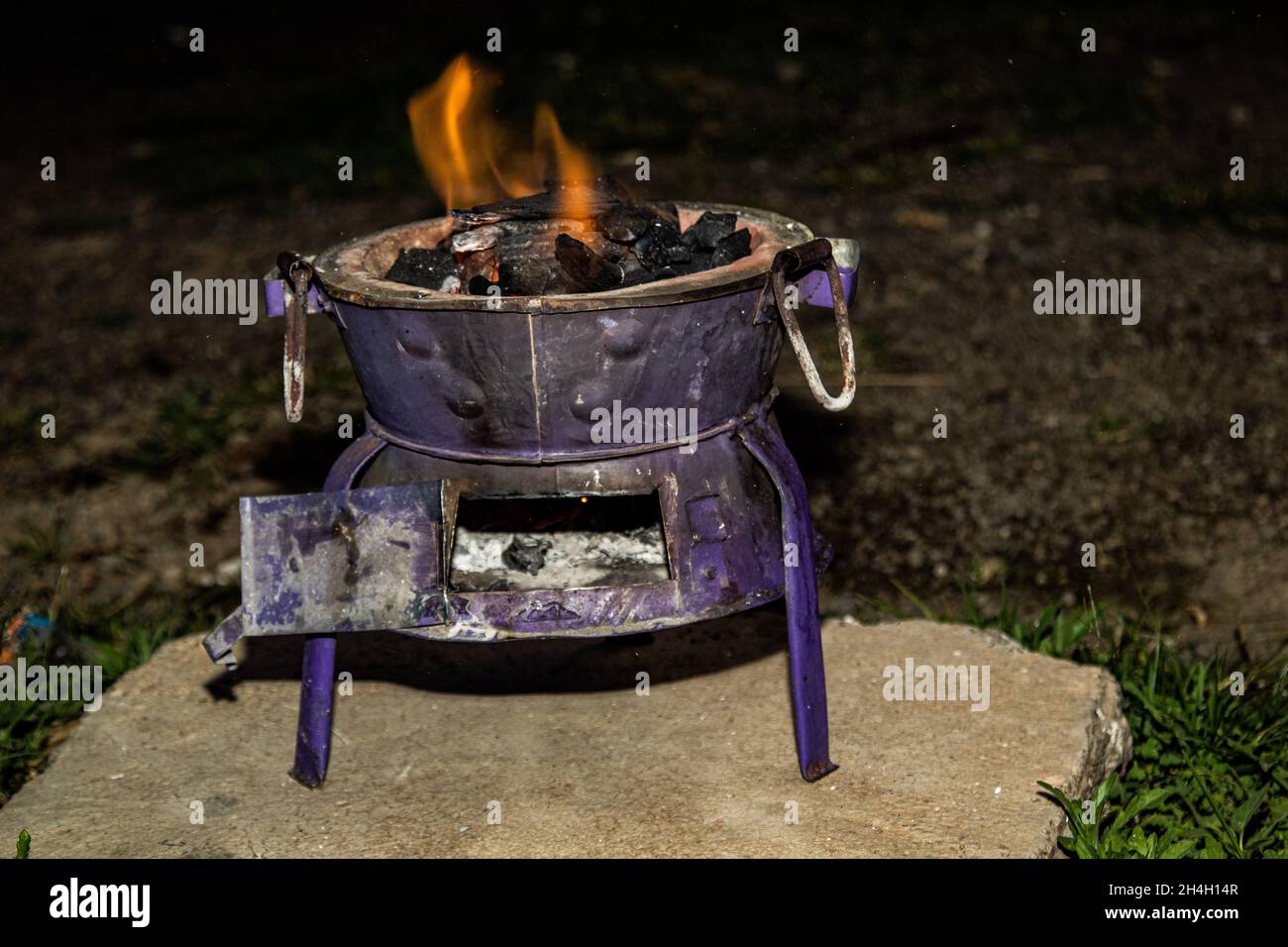 A traditional cooking stove with burning charcoal. Trees capture carbon ...