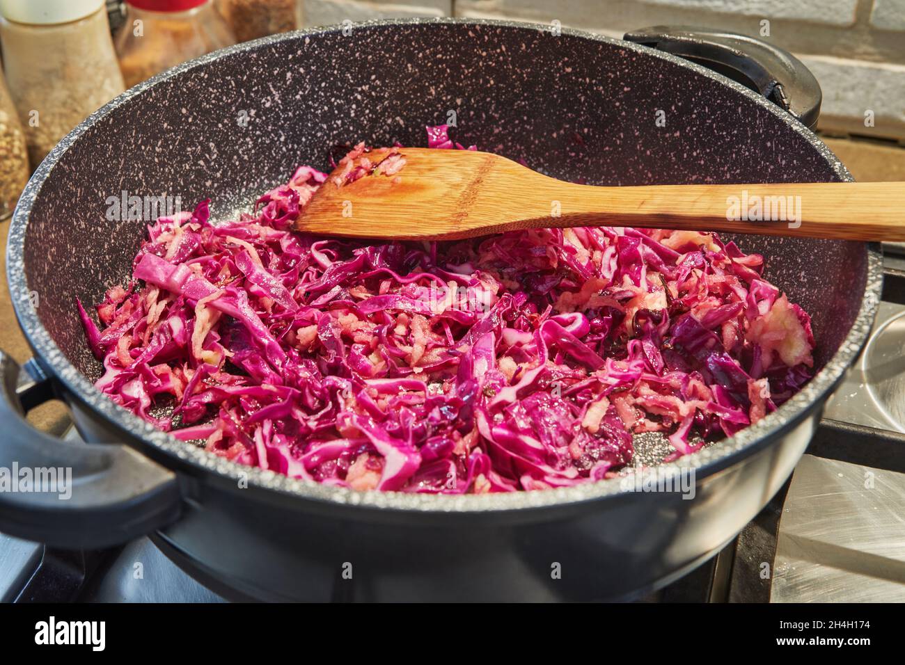 Red cabbage is fried in pan on gas stove Stock Photo - Alamy