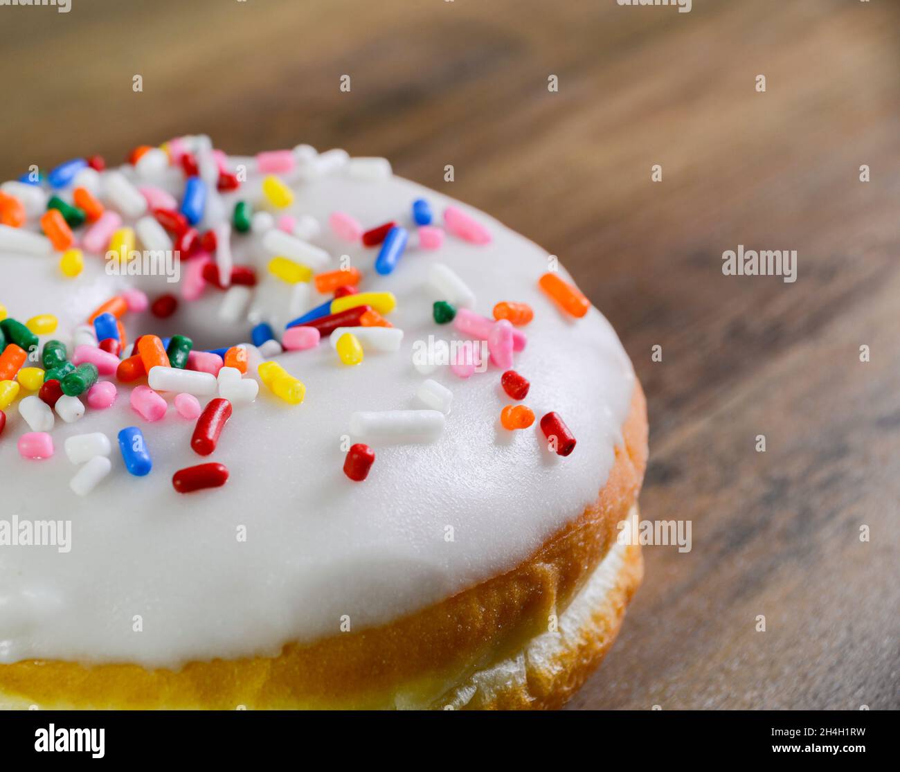 Donut with white icing and sprinkles Stock Photo - Alamy