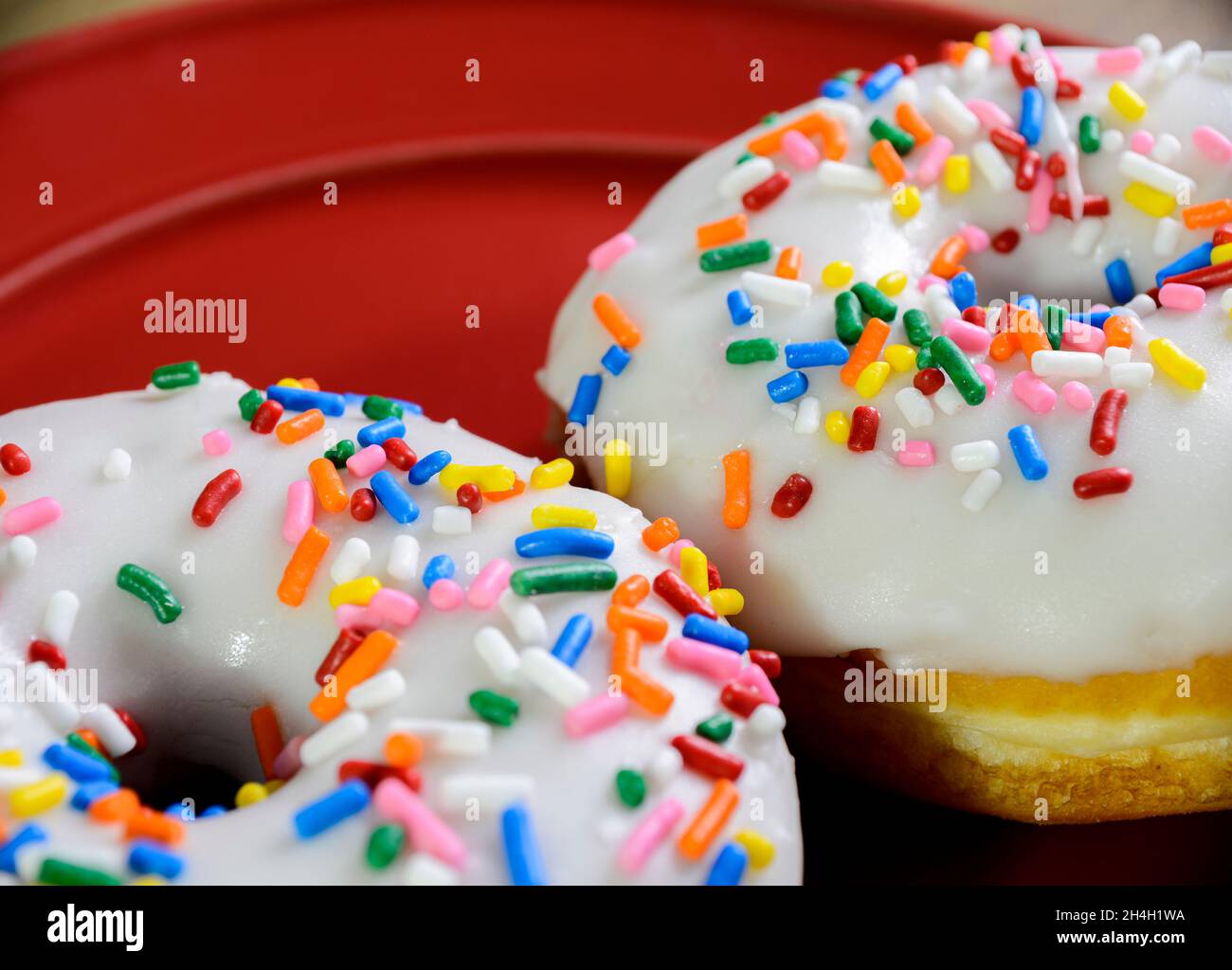 Donut with white icing and sprinkles Stock Photo - Alamy
