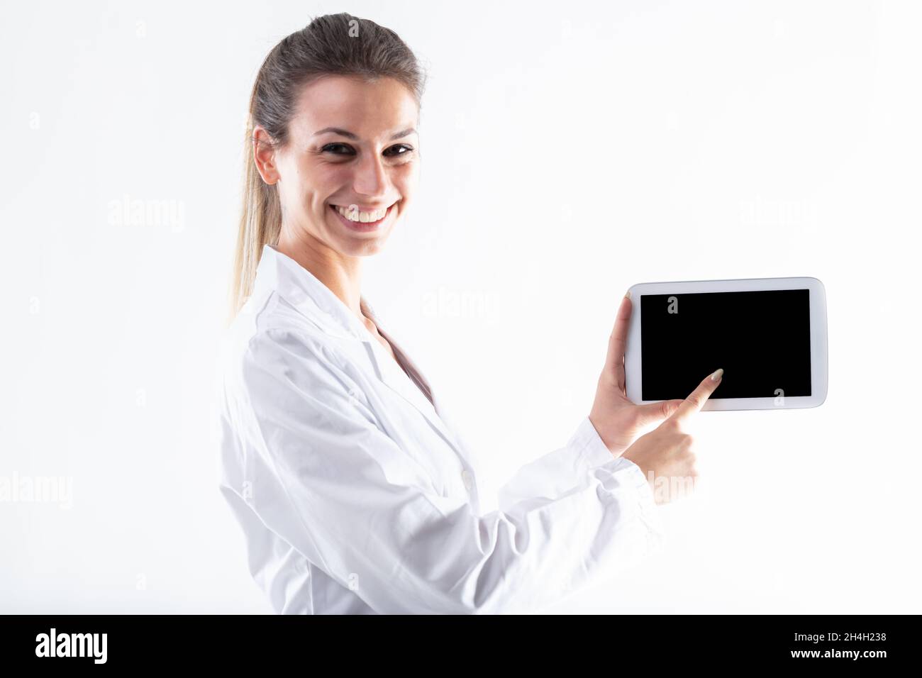 Smiling happy doctor displaying and pointing to a blank tablet held ...