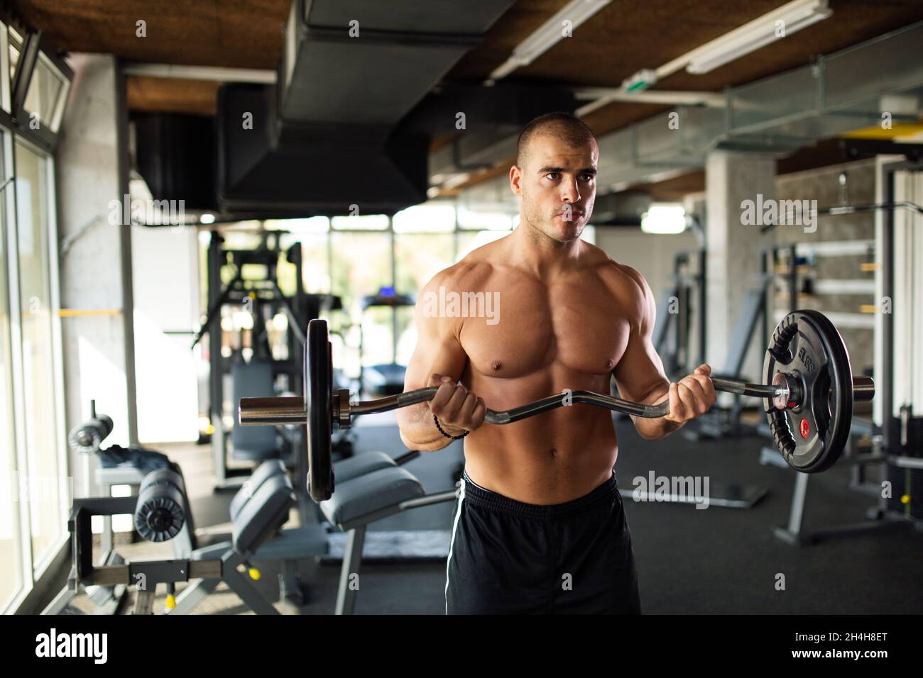 Young fit man exercising in a gym to stay healthy. Sport people workout ...