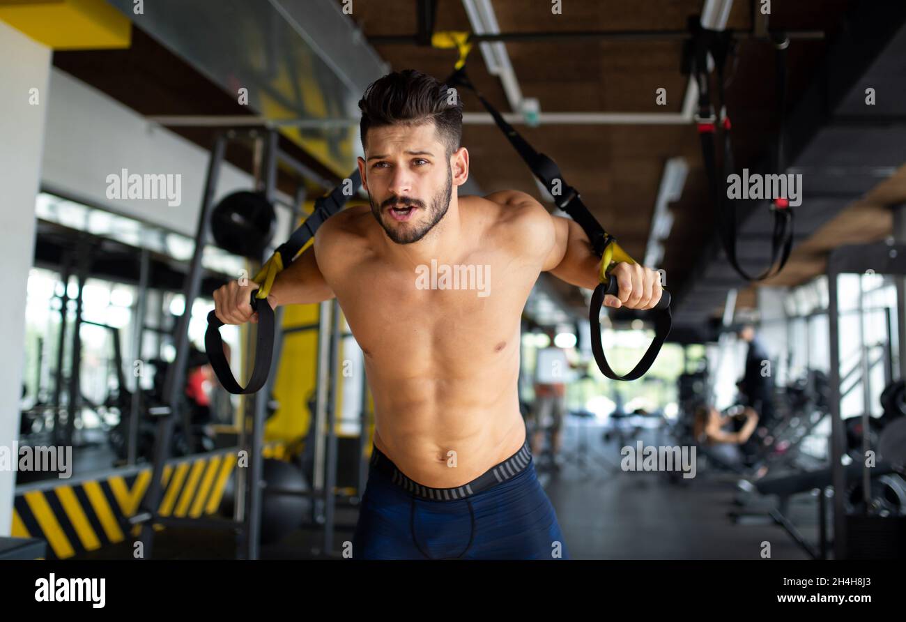 Young fit man exercising in a gym. Sport people healthy lifestyle ...