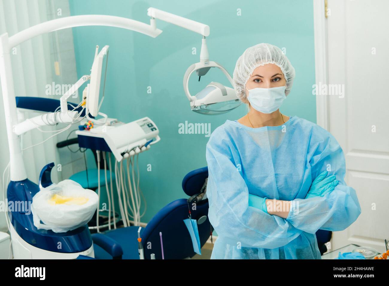 a female dentist wearing a medical mask and rubber gloves poses for the ...