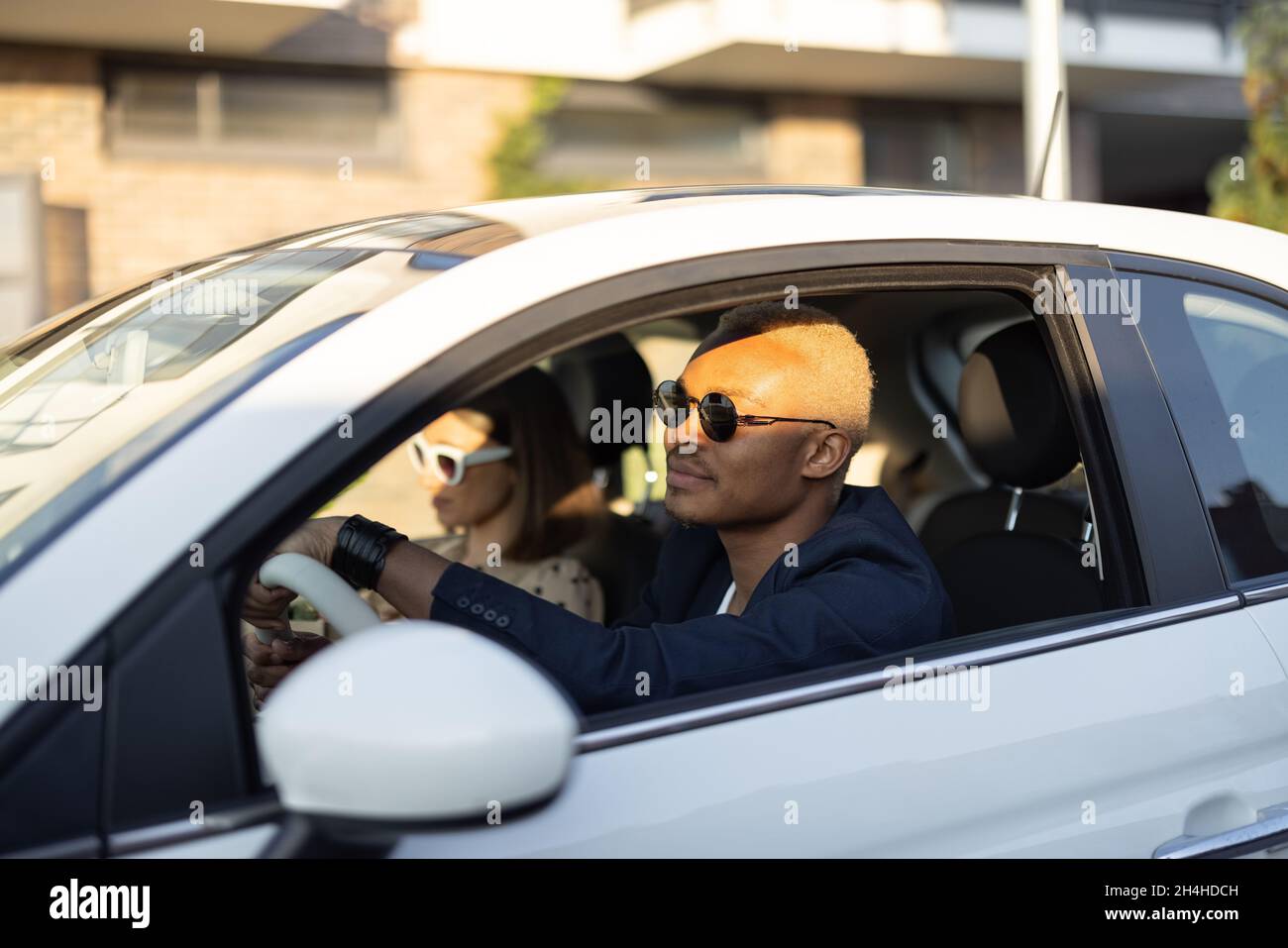 Happy multiracial couple driving at car together Stock Photo - Alamy