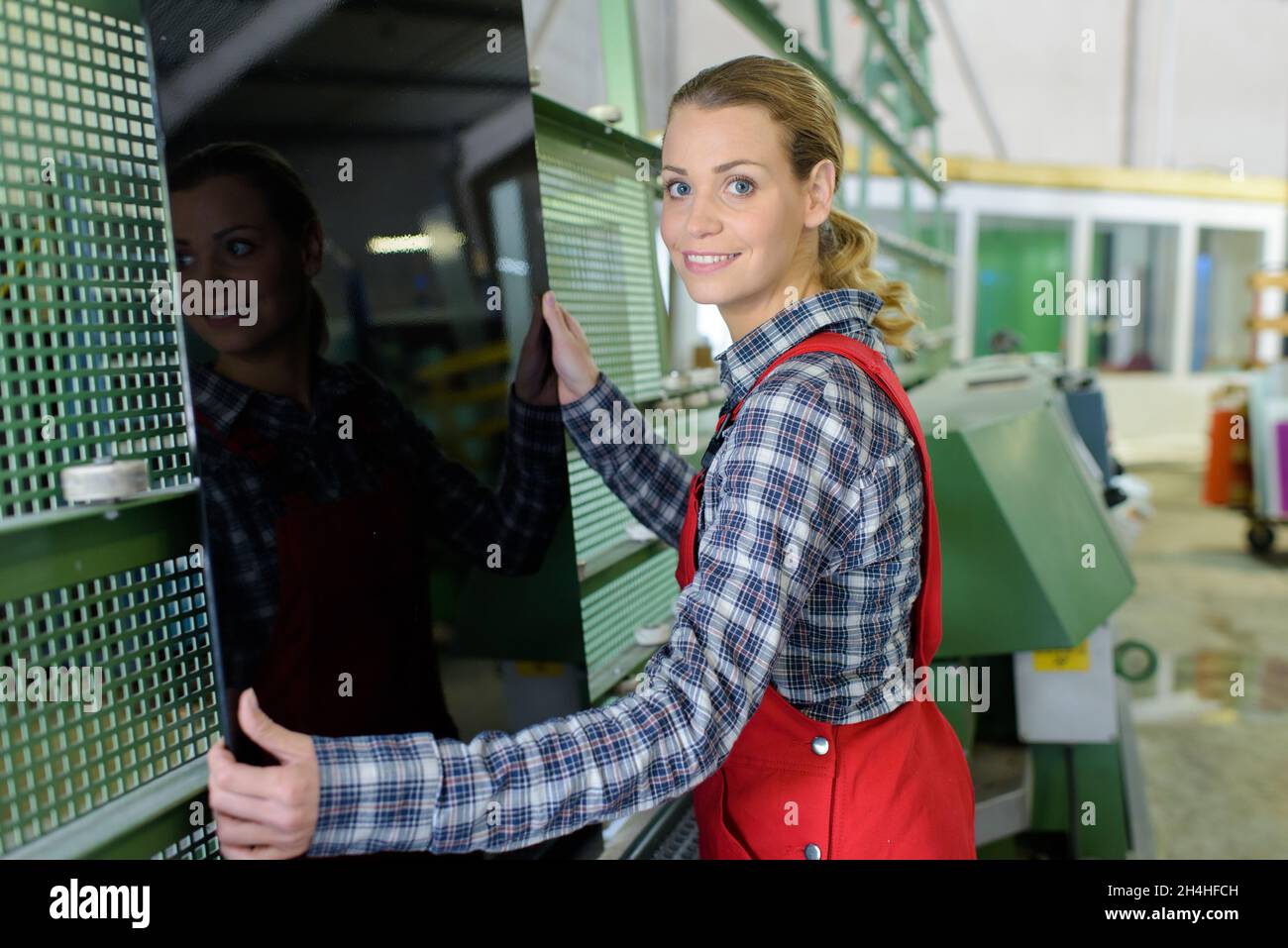 worker in a factory carrying a board Stock Photo - Alamy