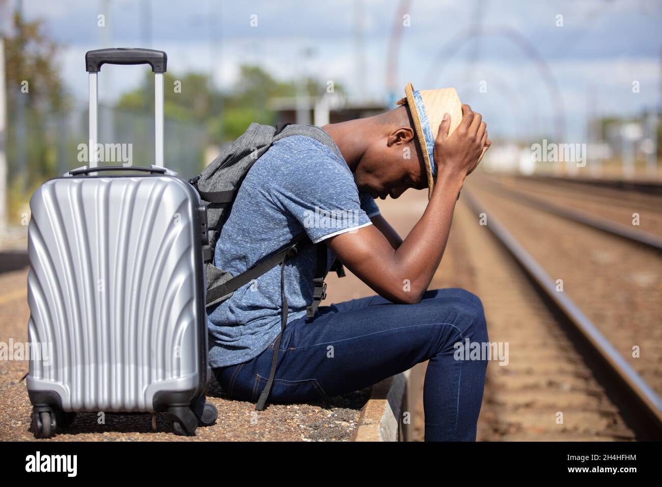 sad man sitting at international airport with luggage Stock Photo - Alamy
