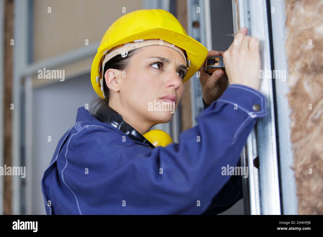 beautiful builder with measuring tape in new apartment Stock Photo - Alamy