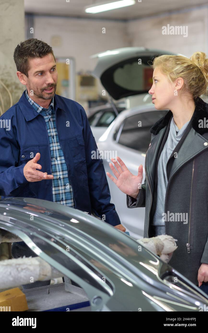 technician talking to female customer at a car station Stock Photo - Alamy