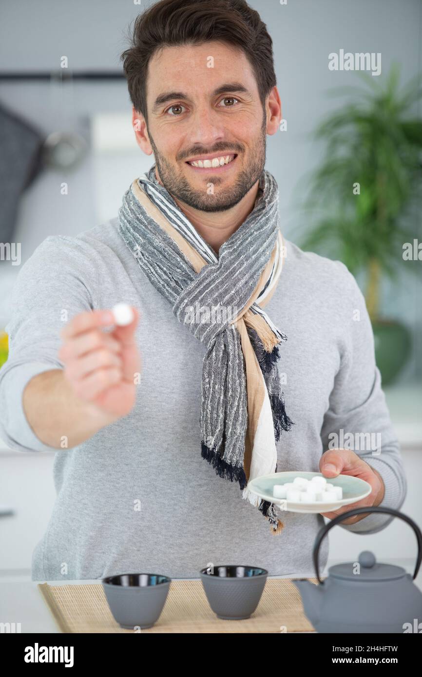 man give you sugar cube for the tea in kitchen Stock Photo - Alamy