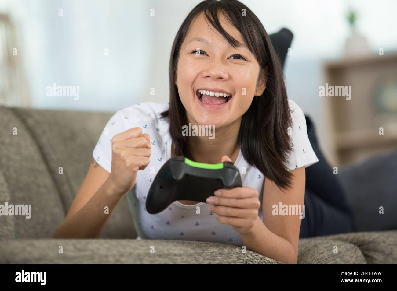 happy woman playing video games holding controller Stock Photo - Alamy