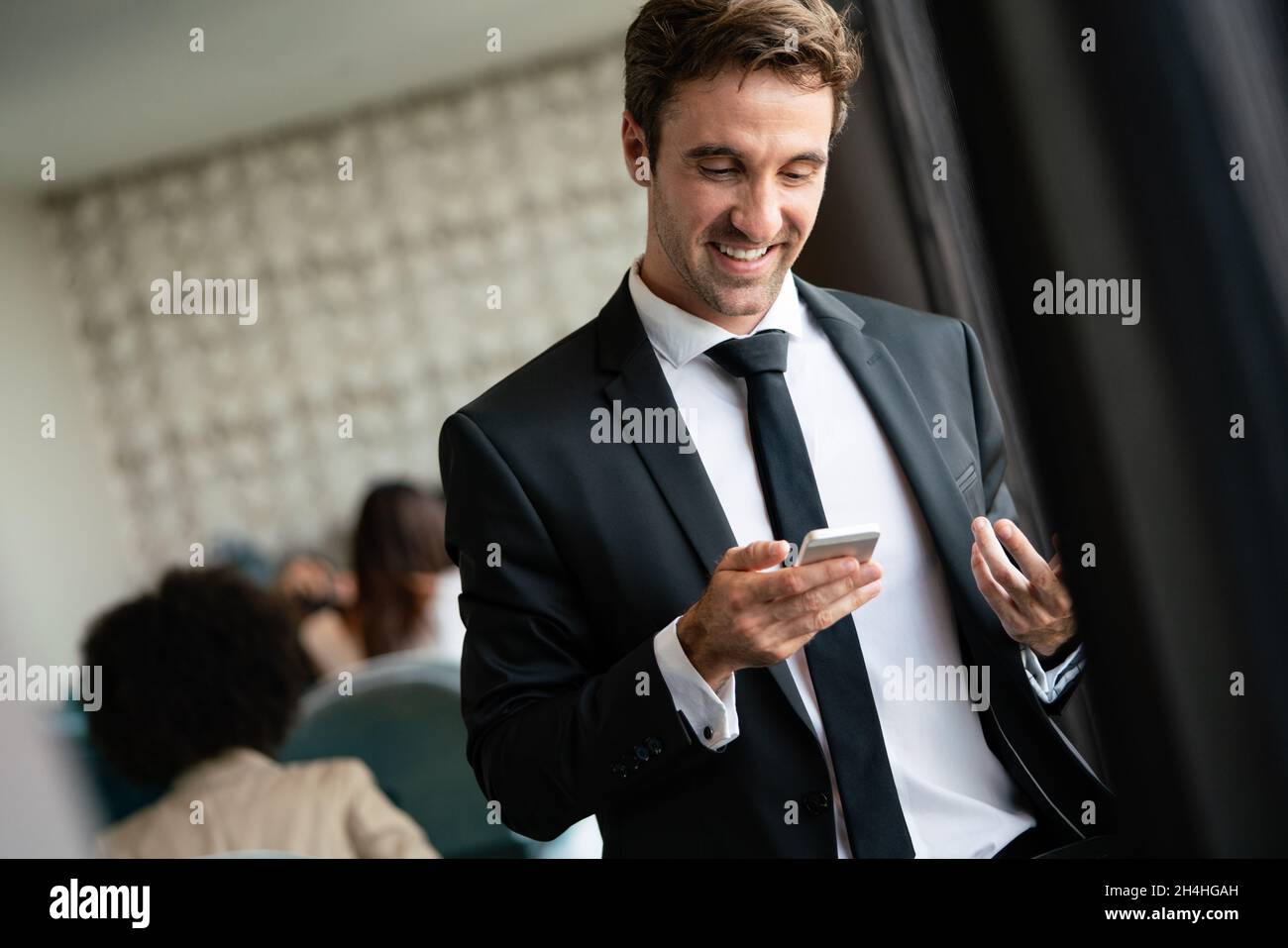 Young businessman sending message with mobile phone Stock Photo - Alamy