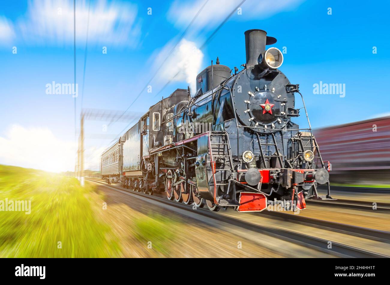Retro old steam locomotive rushes at speed with a passenger train Stock ...