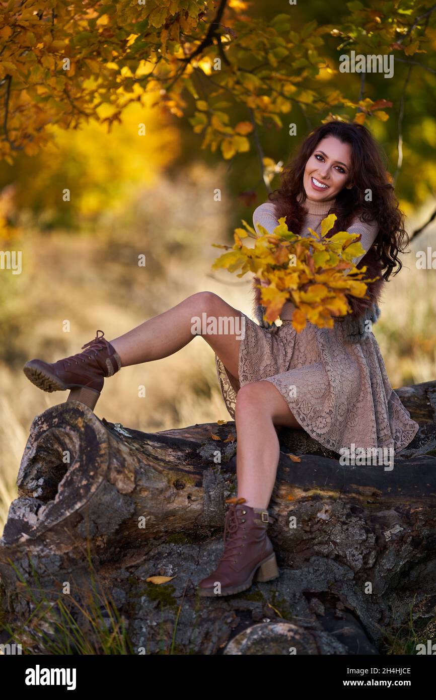 Beautiful elegant young woman posing outdoor in the fall vibrant colors ...