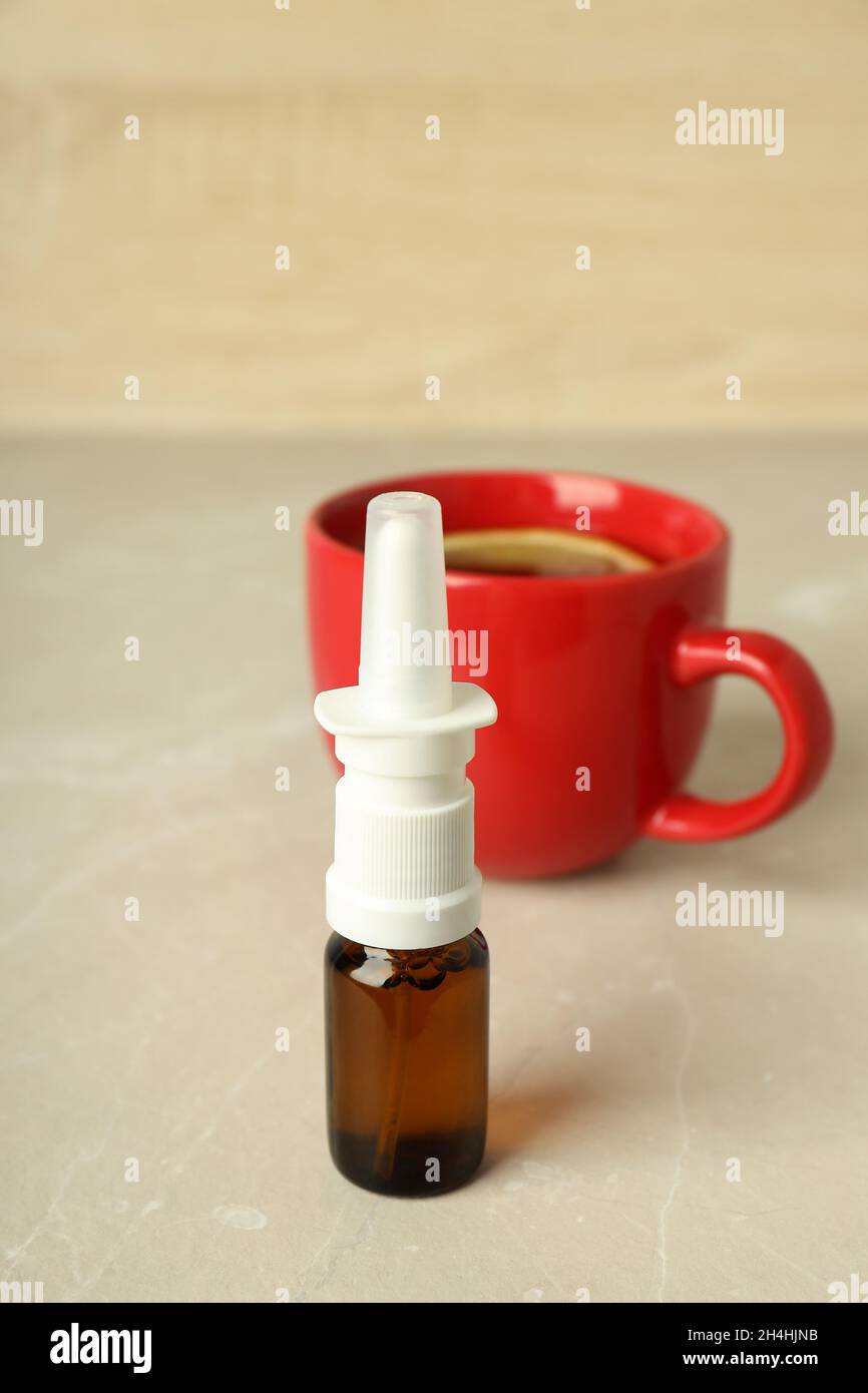 Blank bottle of nasal spray and cup of tea on light table Stock Photo ...