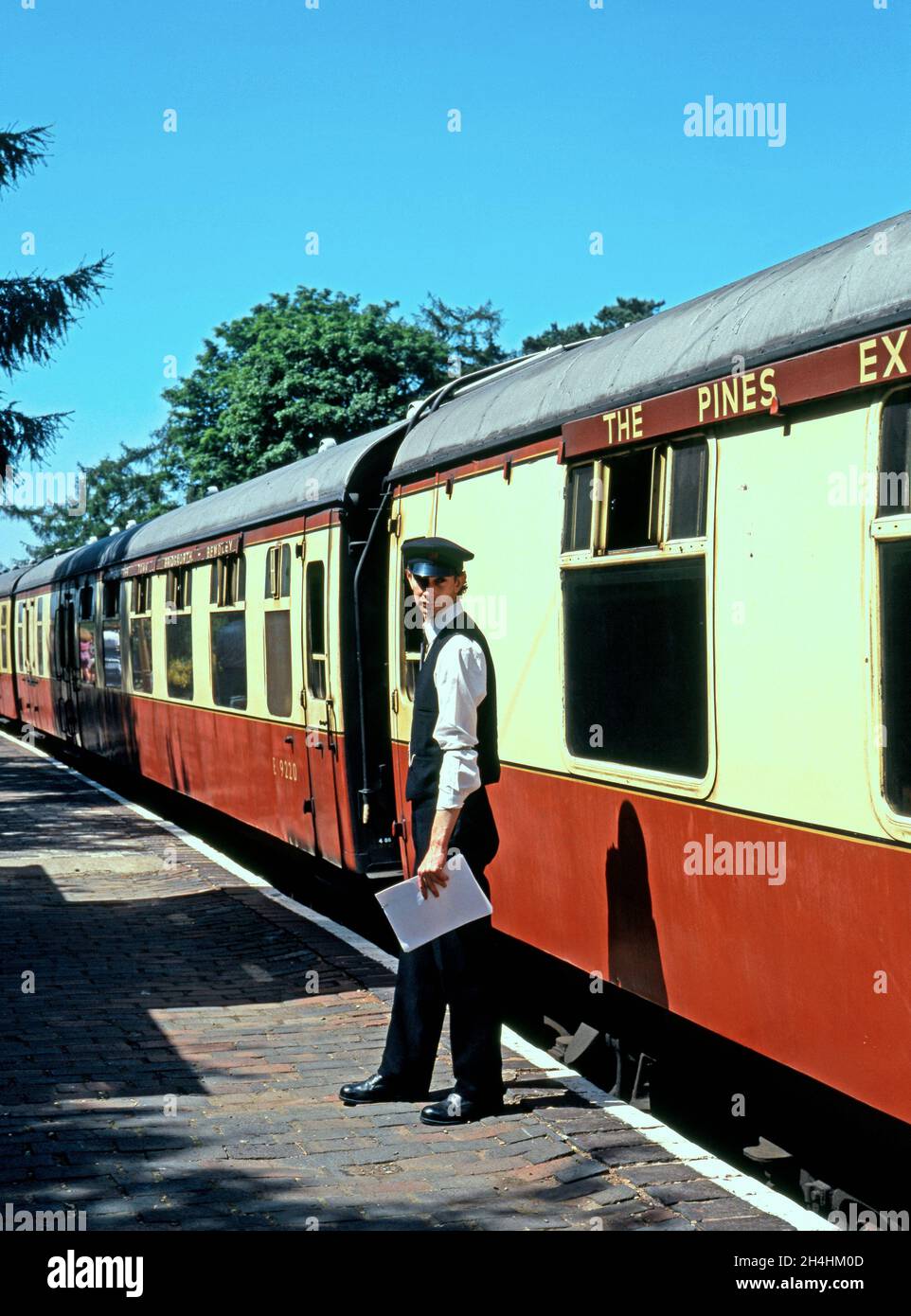 Station porter standing by railway carriages, Severn Valley Railway ...