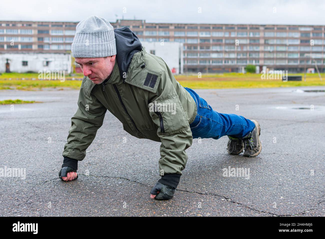 An athlete in cold autumn weather is engaged in fitness outdoors ...