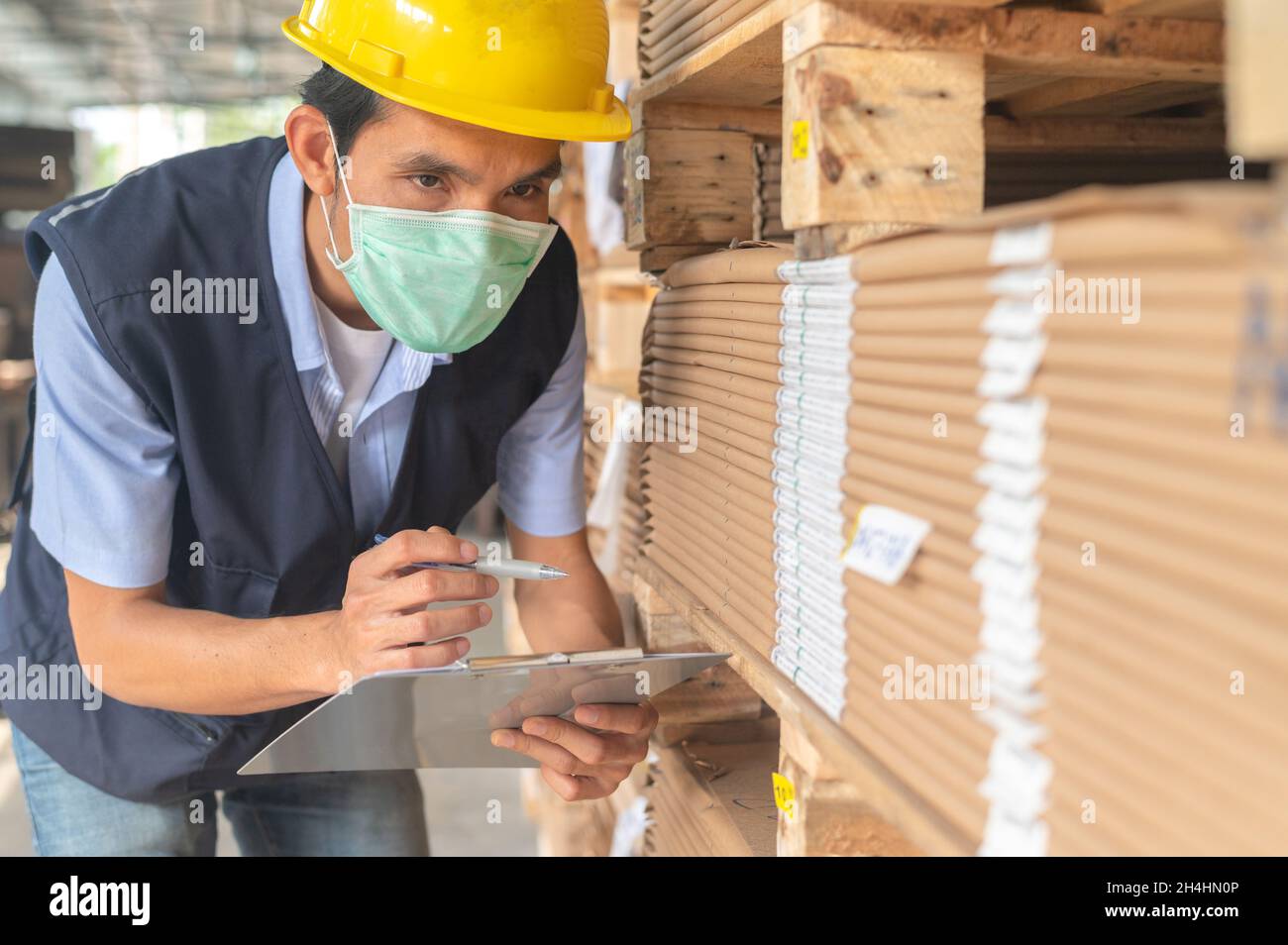Worker checking raw material inventory in factory Stock Photo - Alamy