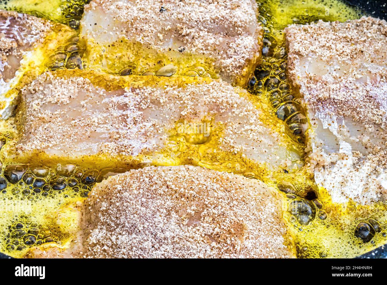 Breaded white fish steaks, fried in a pan with vegetable oil Stock ...