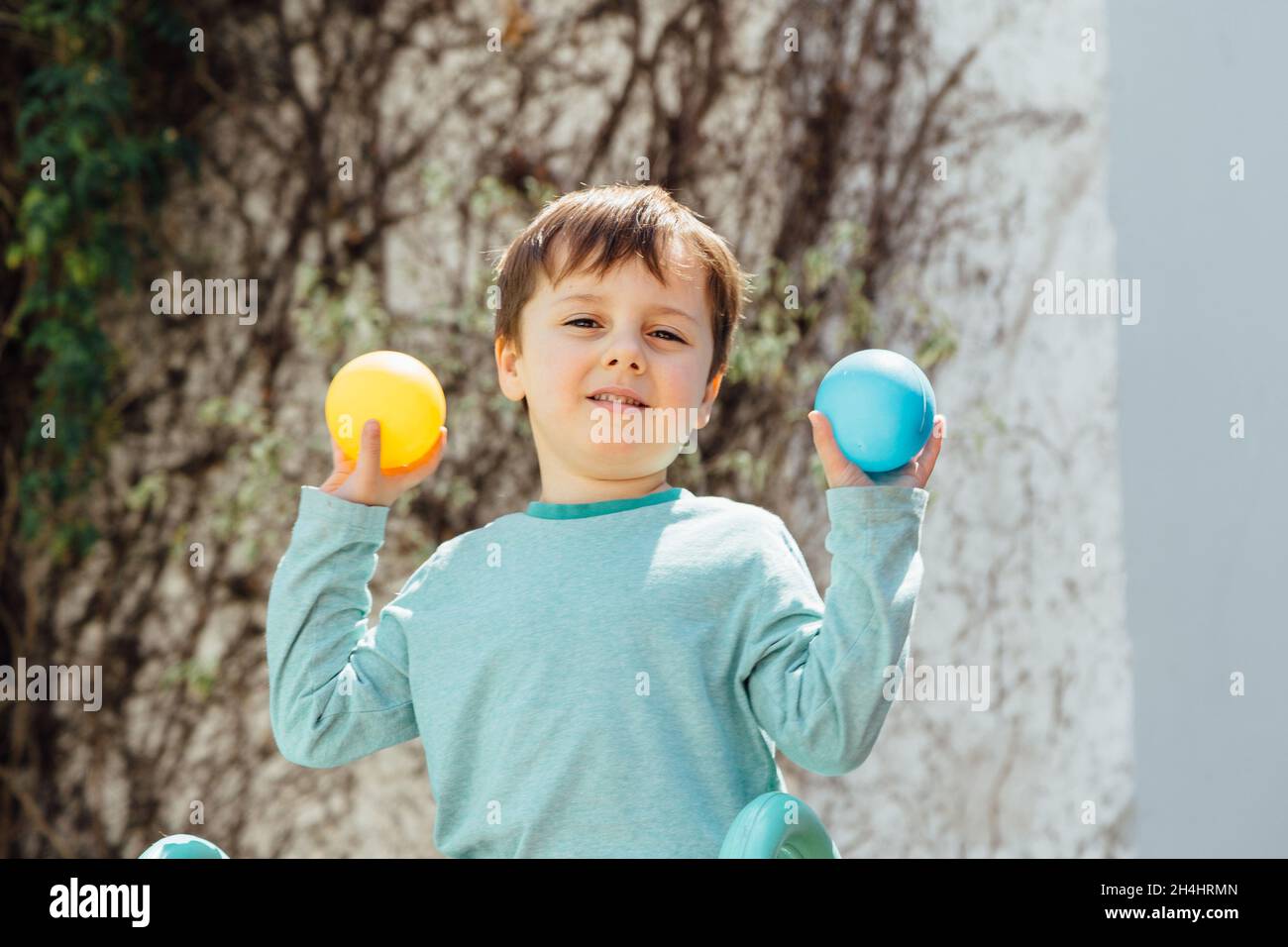 Child with colored plastic balls in his hands Stock Photo - Alamy