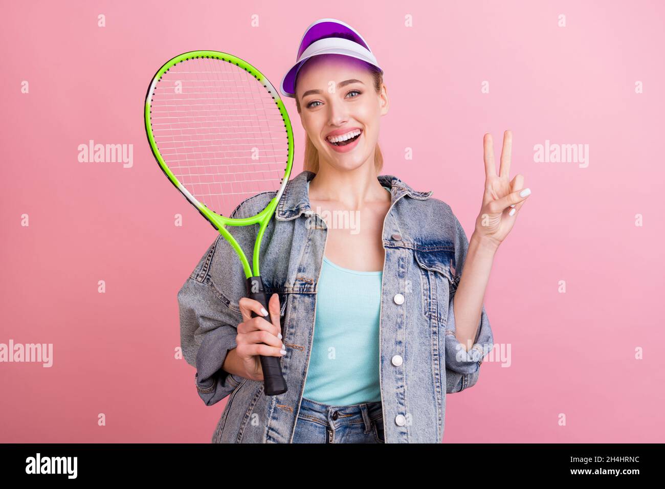 Photo of cool young sporty lady hold racket show v-sign wear jeans ...