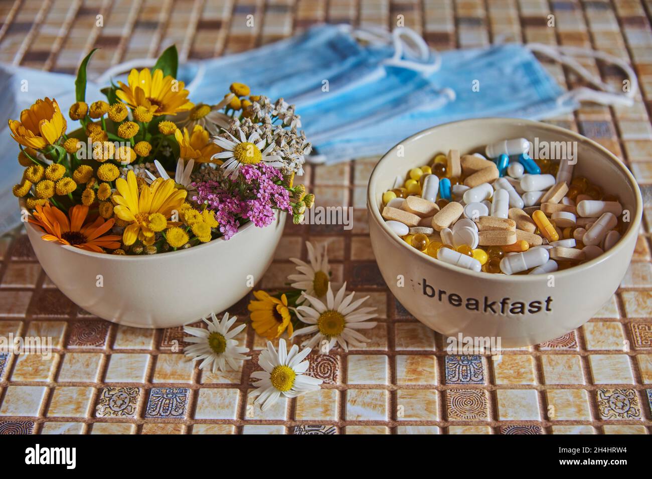 A ceramic bowl with medicinal herbs and a bowl with various pills and ...