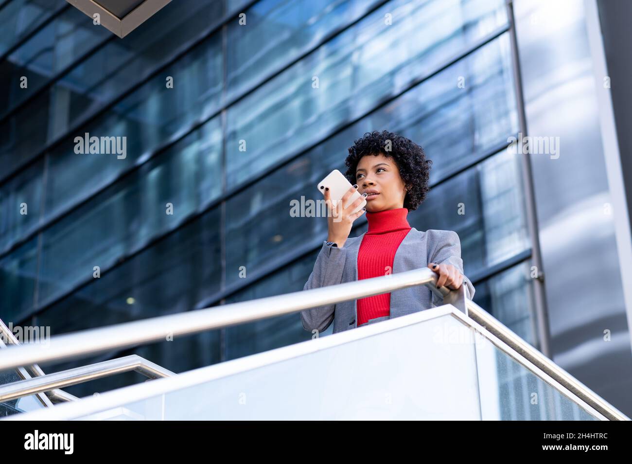 Young African-American businesswoman sending a voice mail on the phone ...
