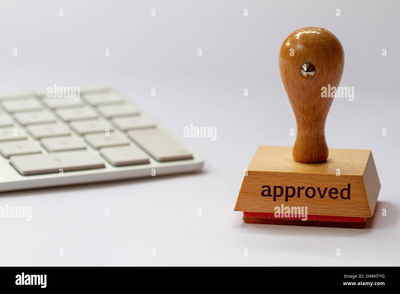 Stamp with the word approved as a sign of an exam. A computer keyboard ...