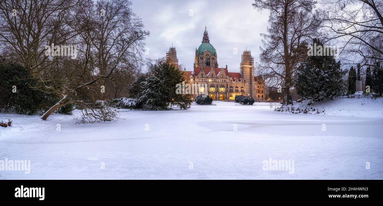 New town hall of Hanover in winter with snow on the pond and branches ...