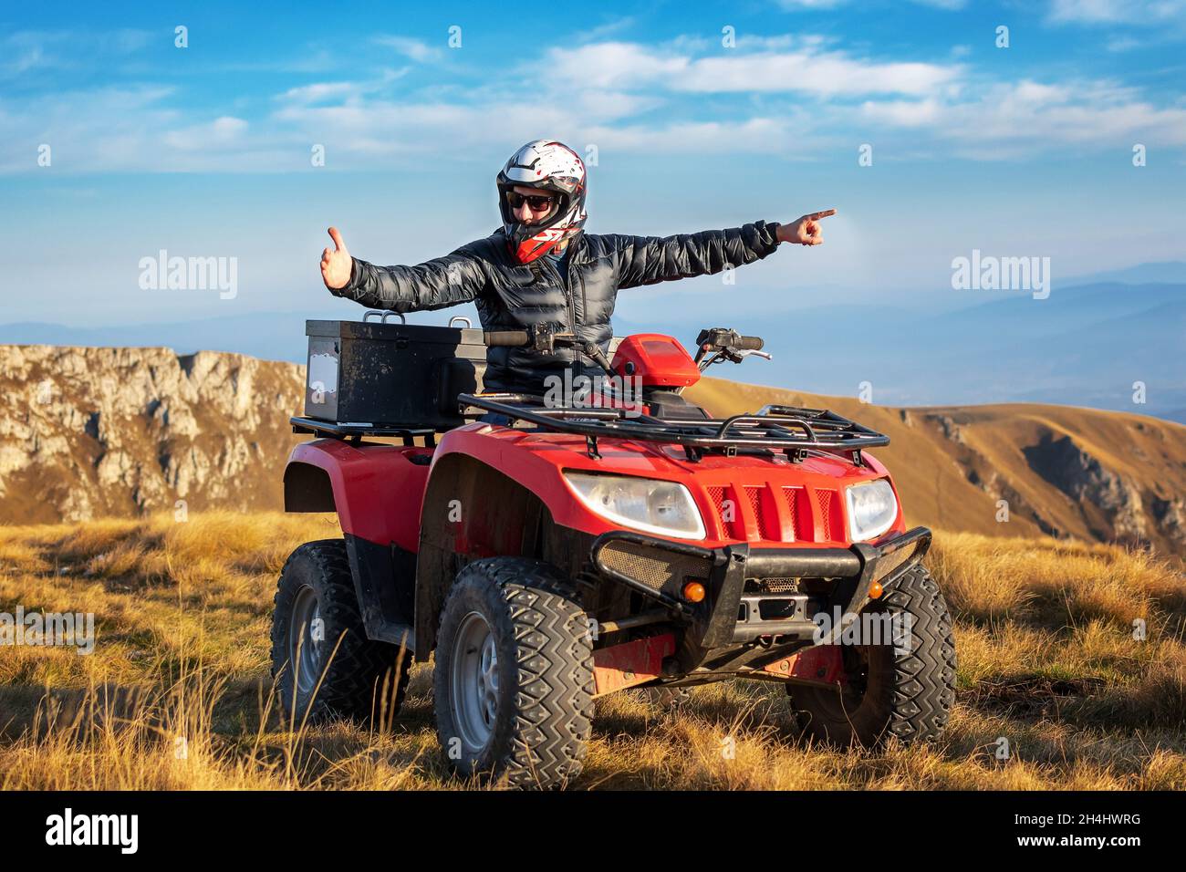A man on a quad bike in the mountains Stock Photo - Alamy