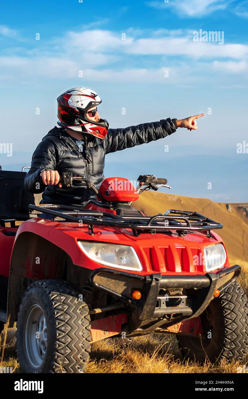 A man on a quad bike in the mountains Stock Photo - Alamy
