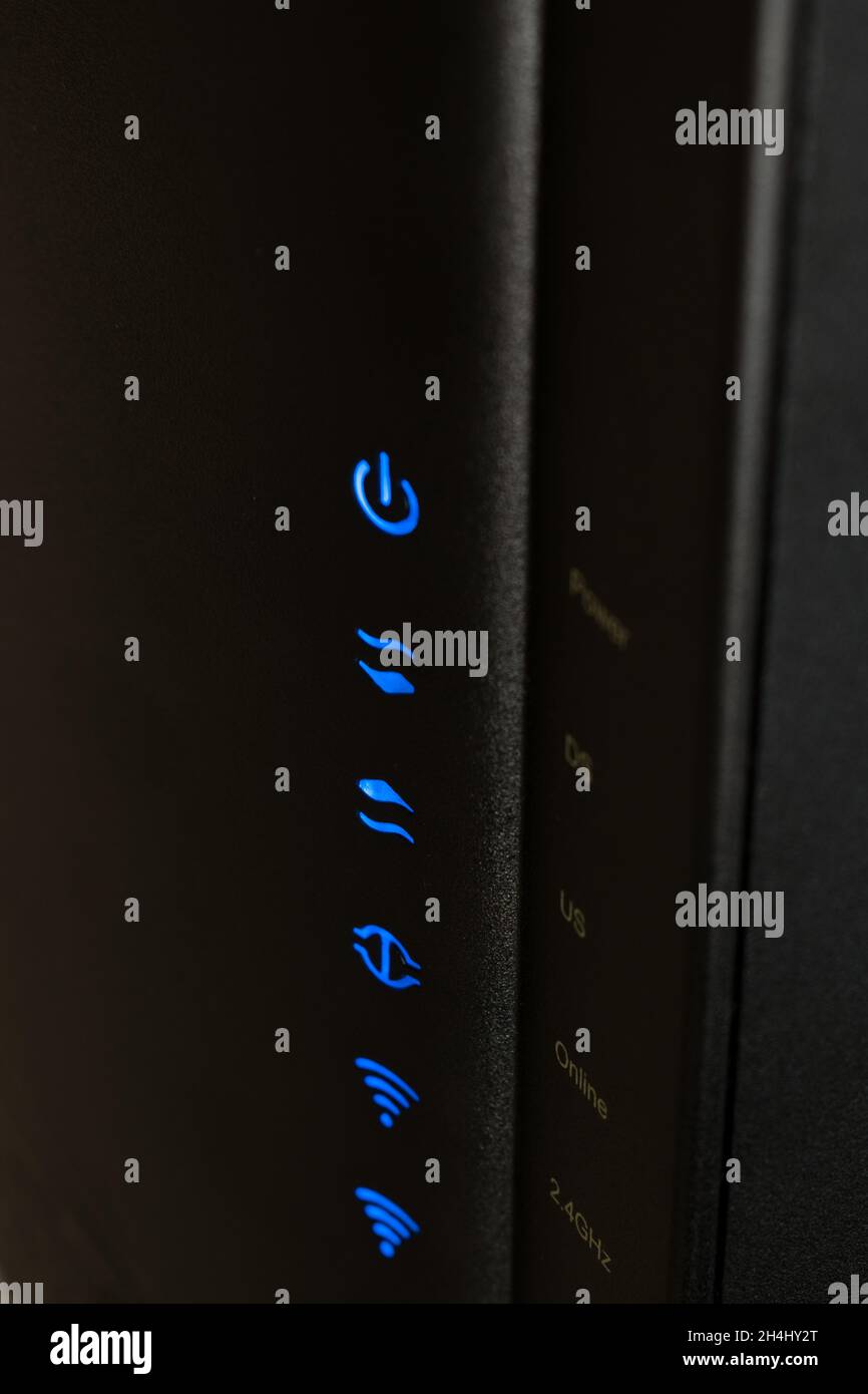 Vertical shot of a lack internet modem with blue light buttons of power ...