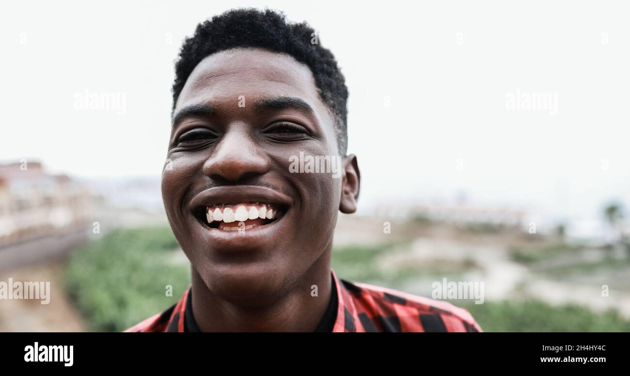 Young african guy smiling on camera outdoor - Focus on face Stock Photo ...