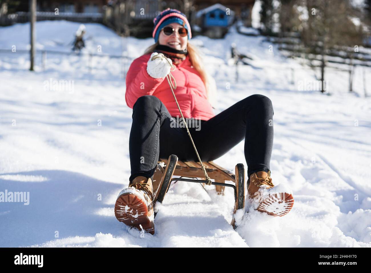 Happy girl speeding with vintage sledding on snow high mountain - Focus ...