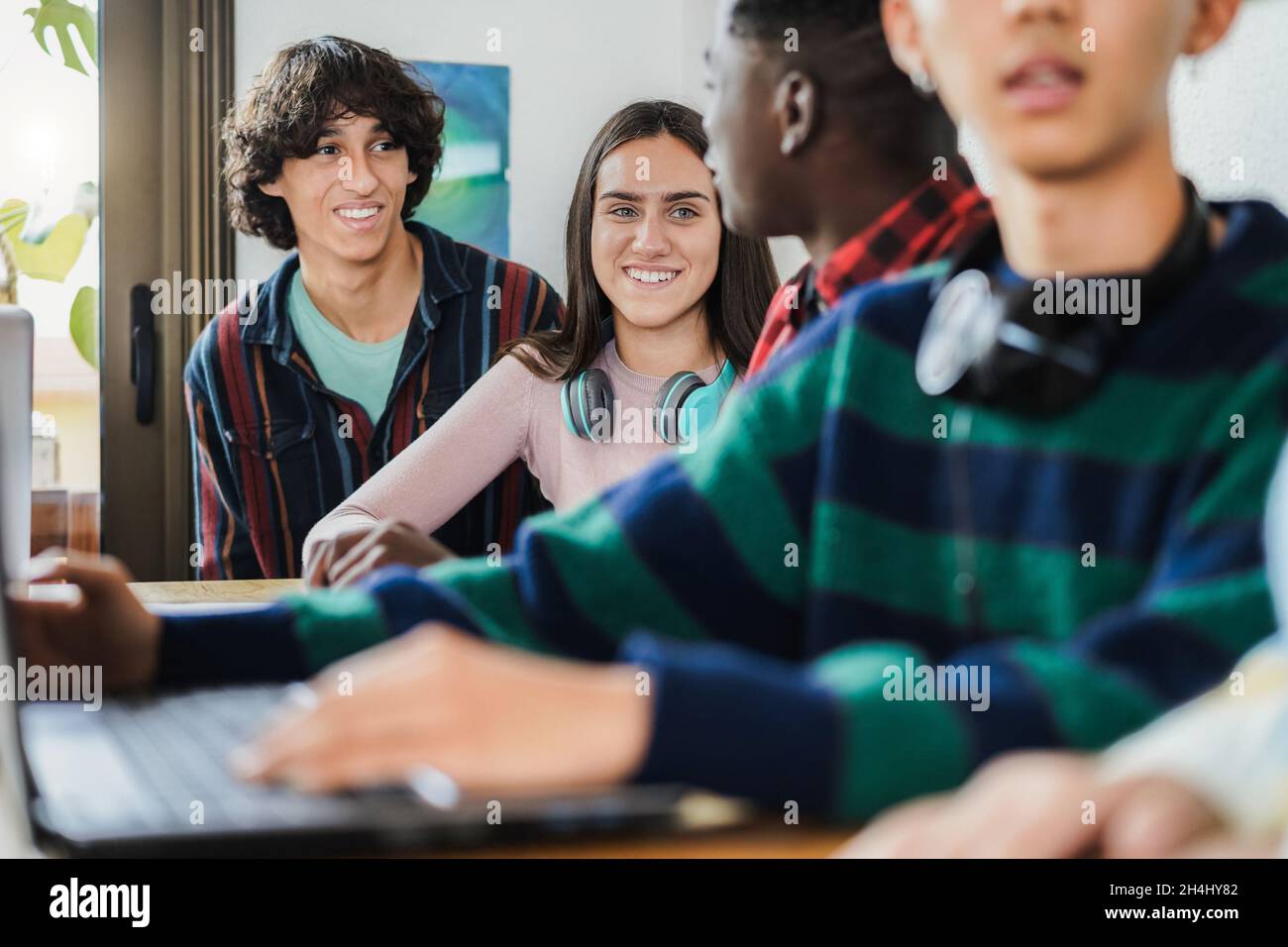 Multiracial students using laptop computers while studying together at ...